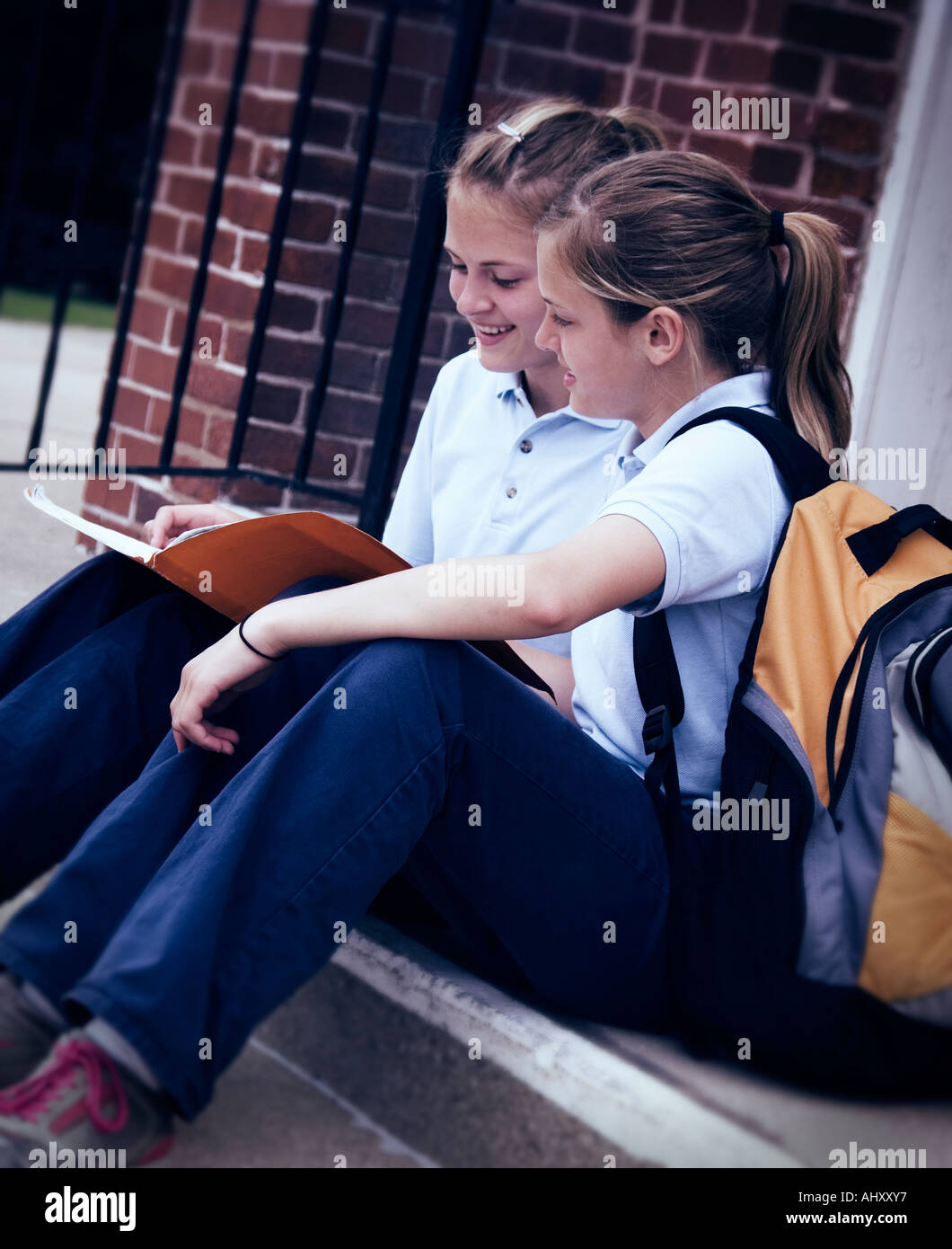 Girls in school uniforms reading a book Stock Photo - Alamy