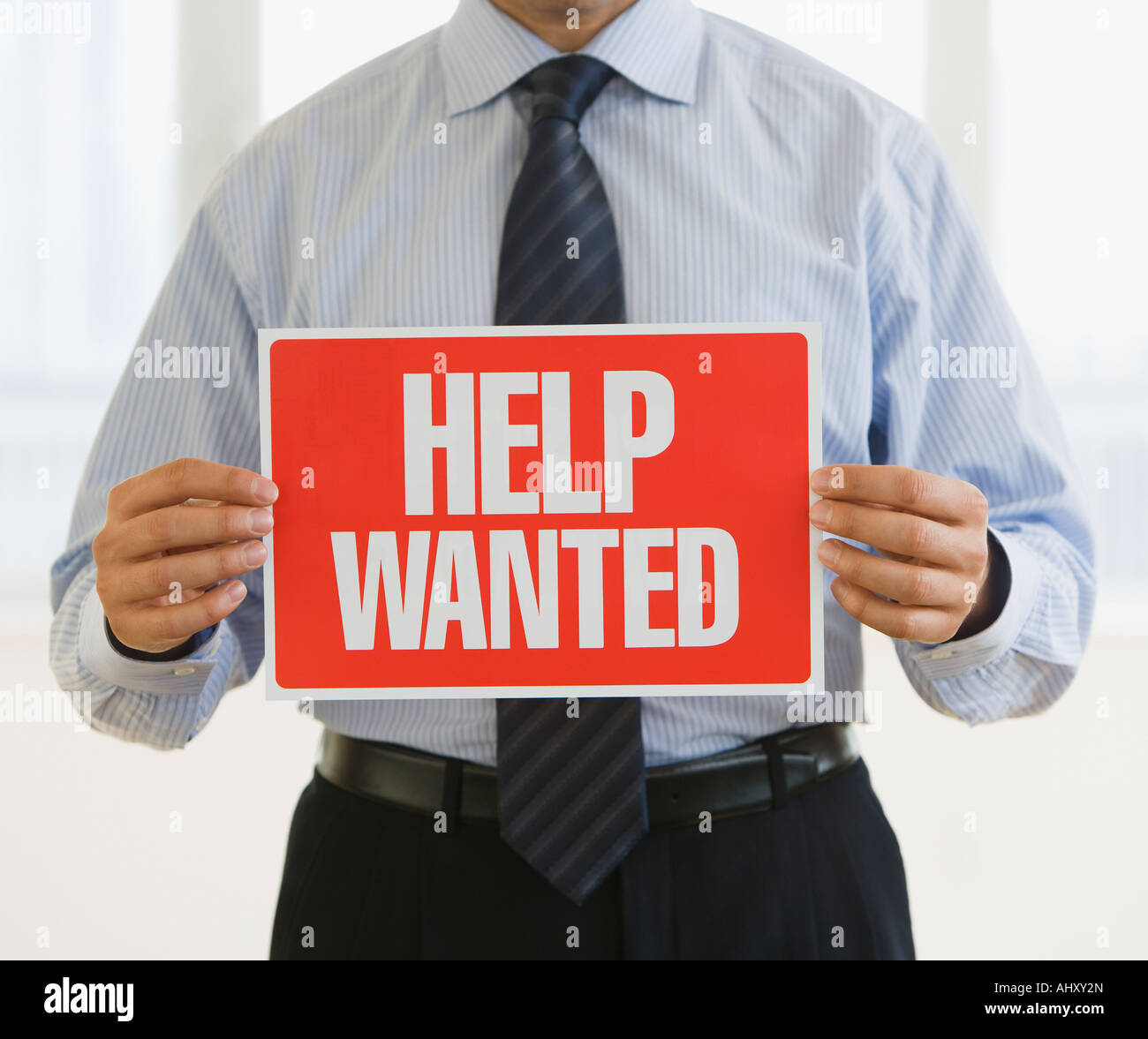 Businessman holding Help Wanted sign Stock Photo - Alamy