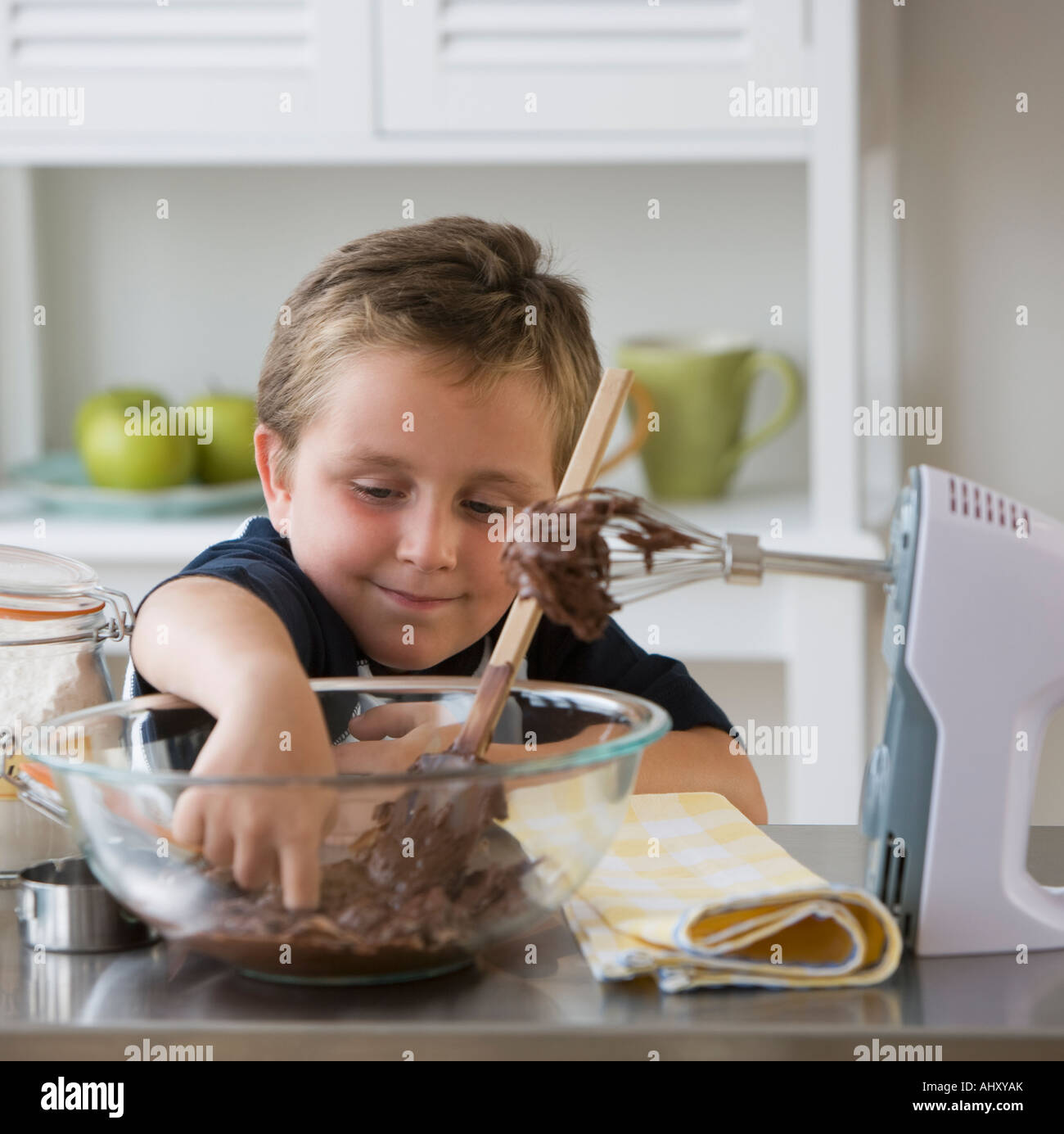 Boy sticking finger into bowl of batter Stock Photo - Alamy