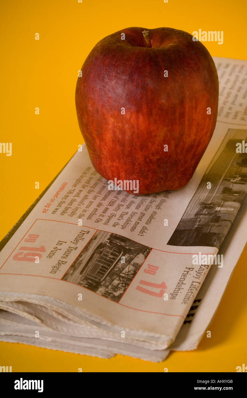 Red apple on newspaper Stock Photo - Alamy