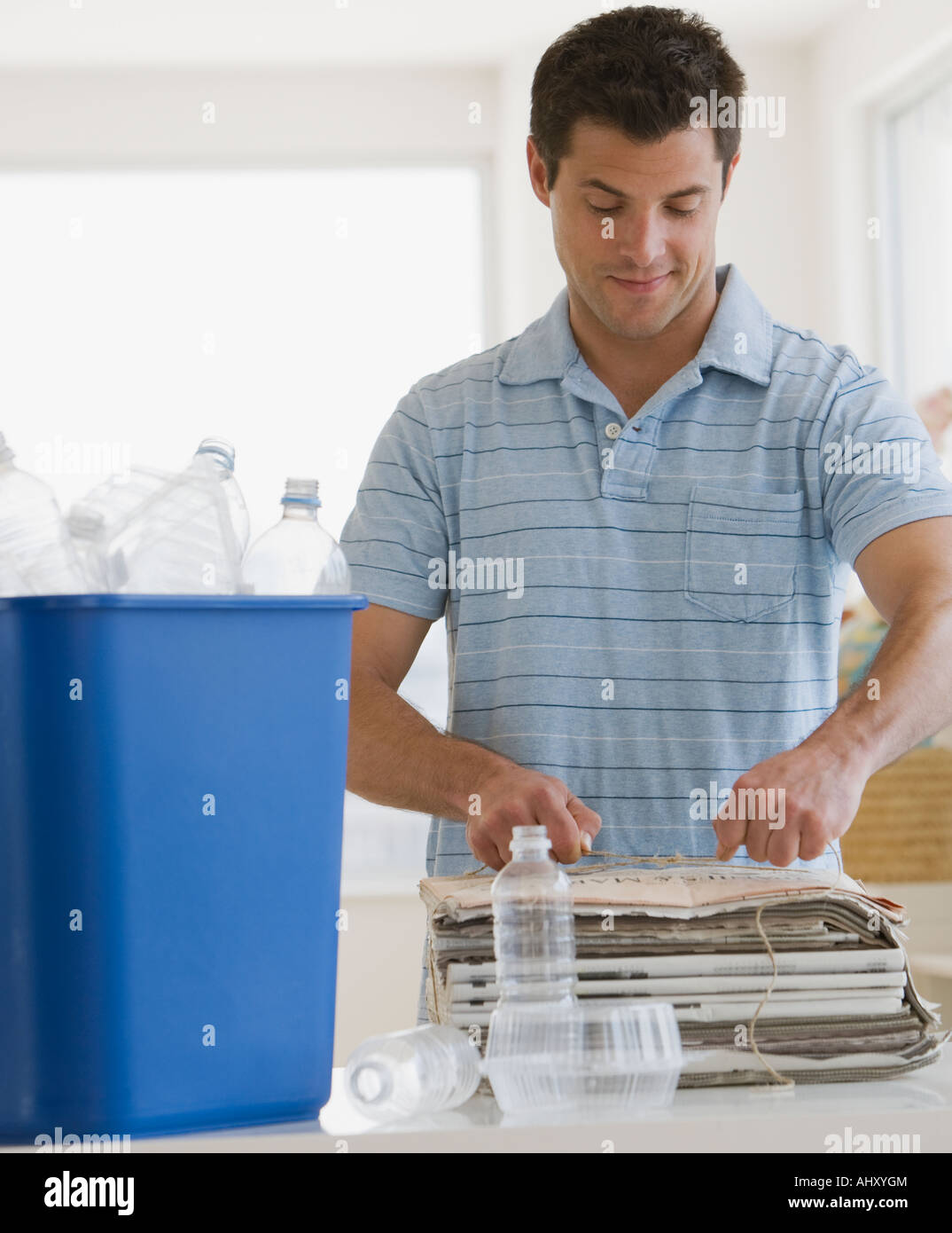 Man recycling newspaper and plastic Stock Photo - Alamy