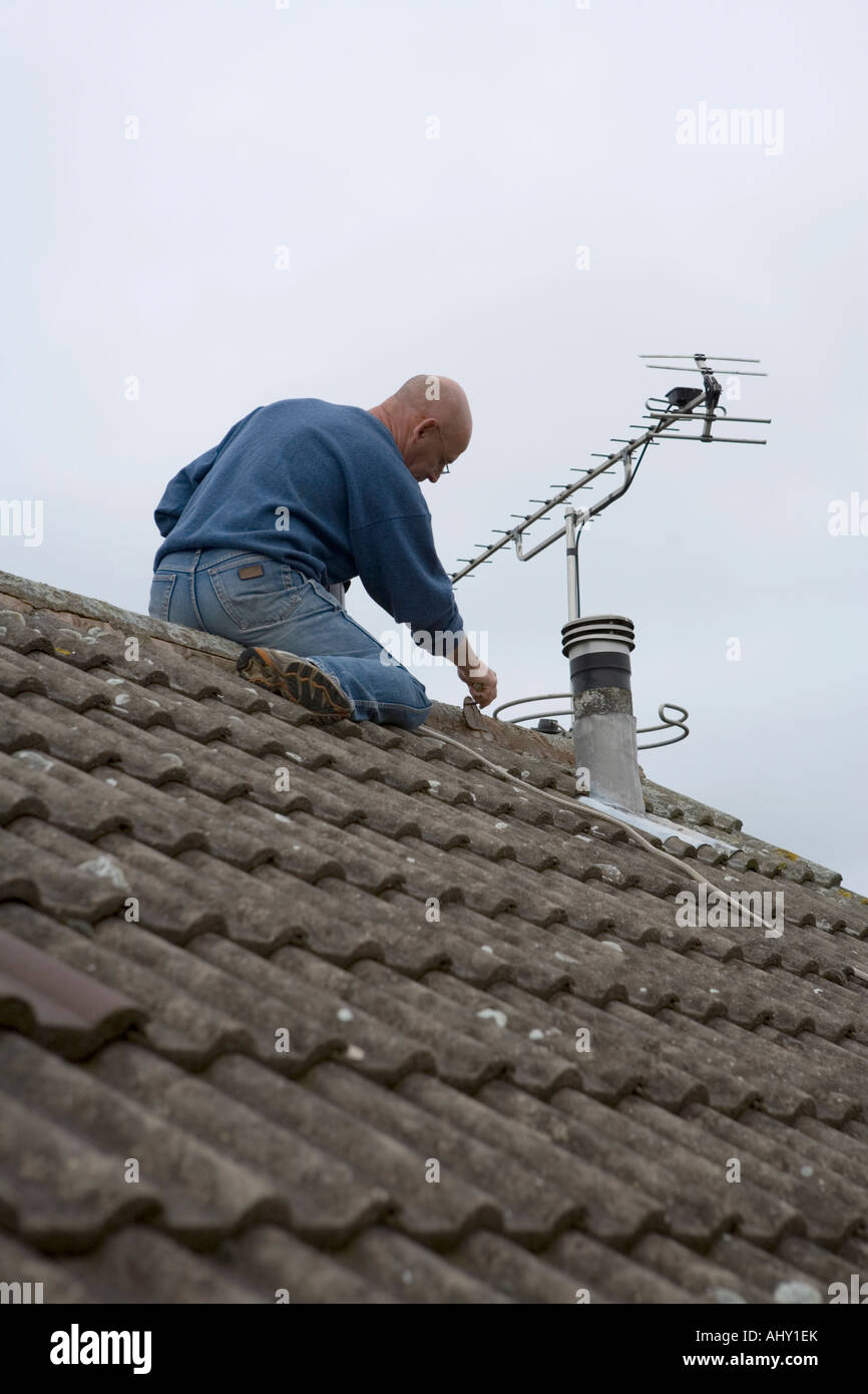 Man pointing ridge tiles on house roof Stock Photo - Alamy