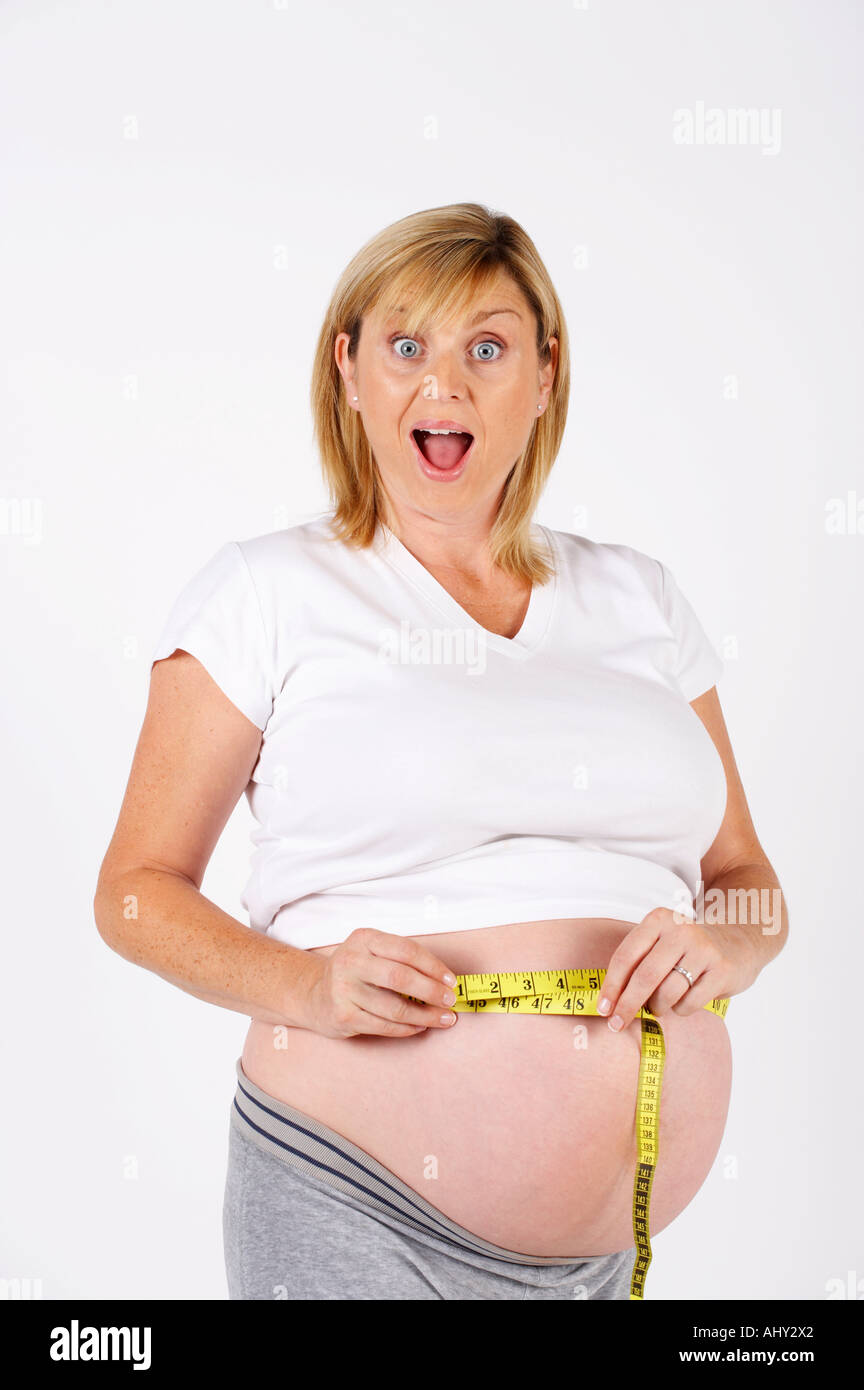 ATTRACTIVE HEALTHY YOUNG PREGNANT WOMAN MEASURING SIZE OF HER BELLY ...