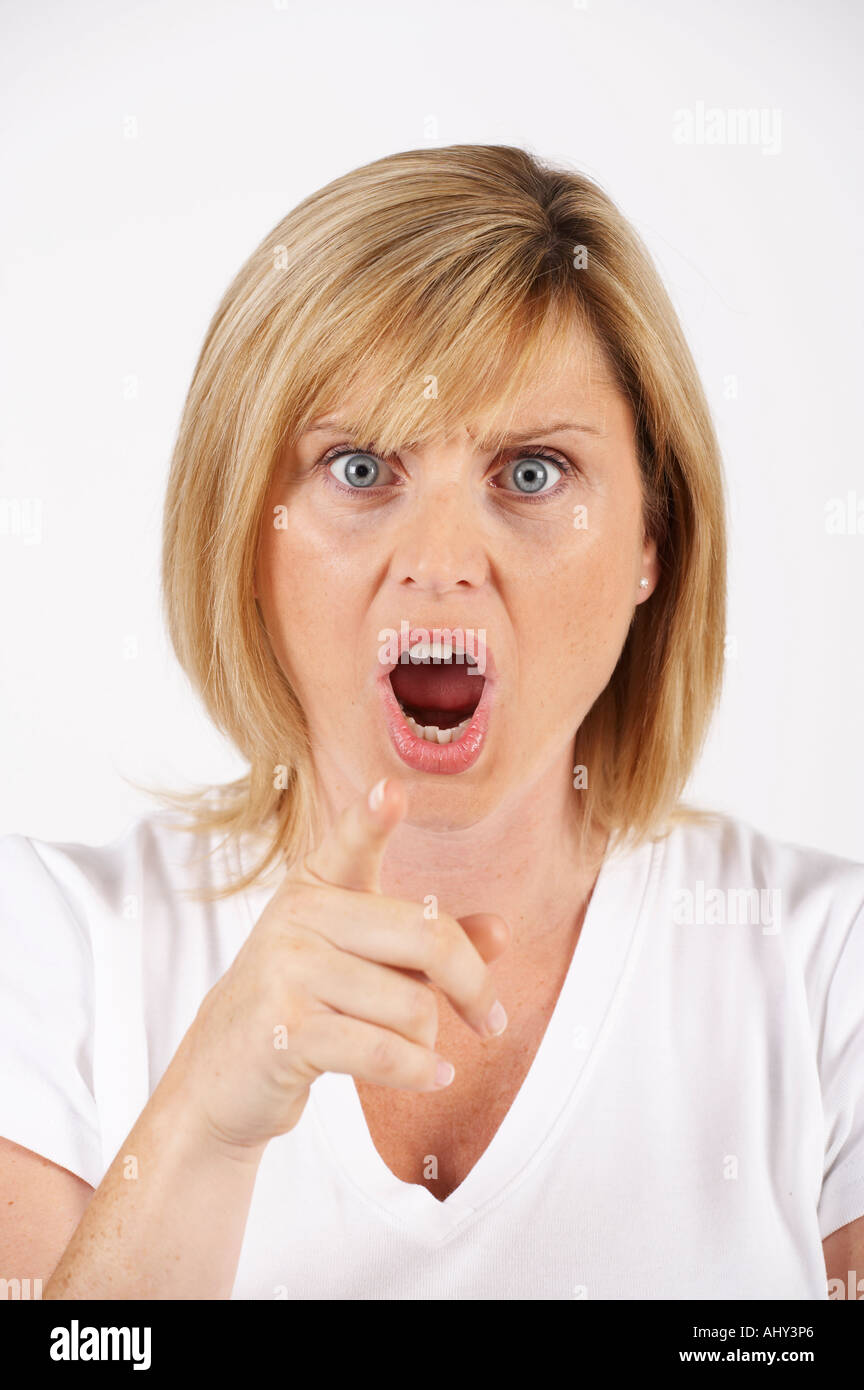 PORTRAIT OF ATTRACTIVE YOUNG BLONDE WOMAN POINTING FINGER AND SHOUTING ...