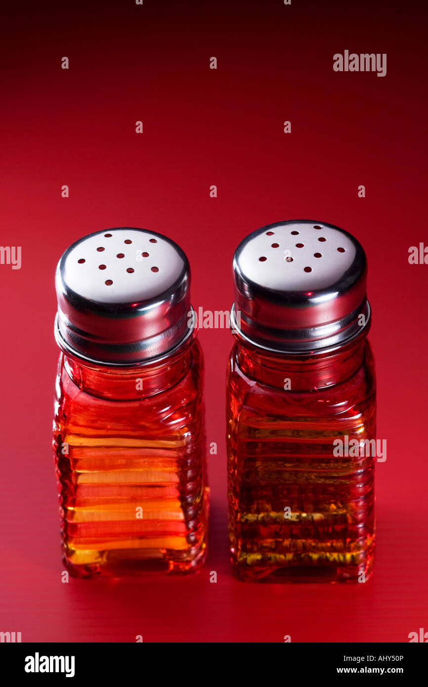Salt and pepper shakers on red background Stock Photo - Alamy