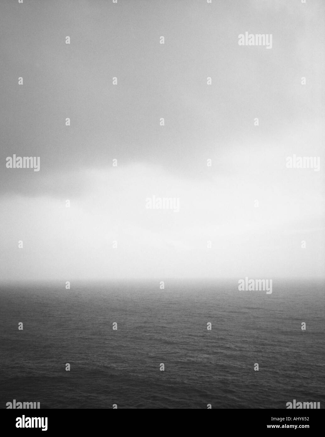 black and white image looking out towards a calm sea taken in cornwall ...