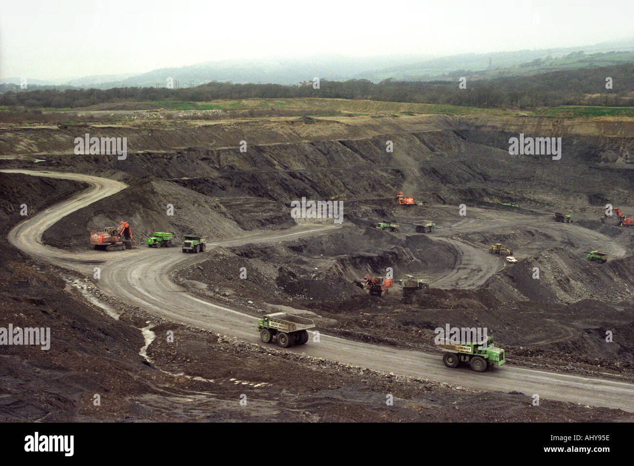 Mechanical shovel and tipper trucks working in opencast coal mine in ...