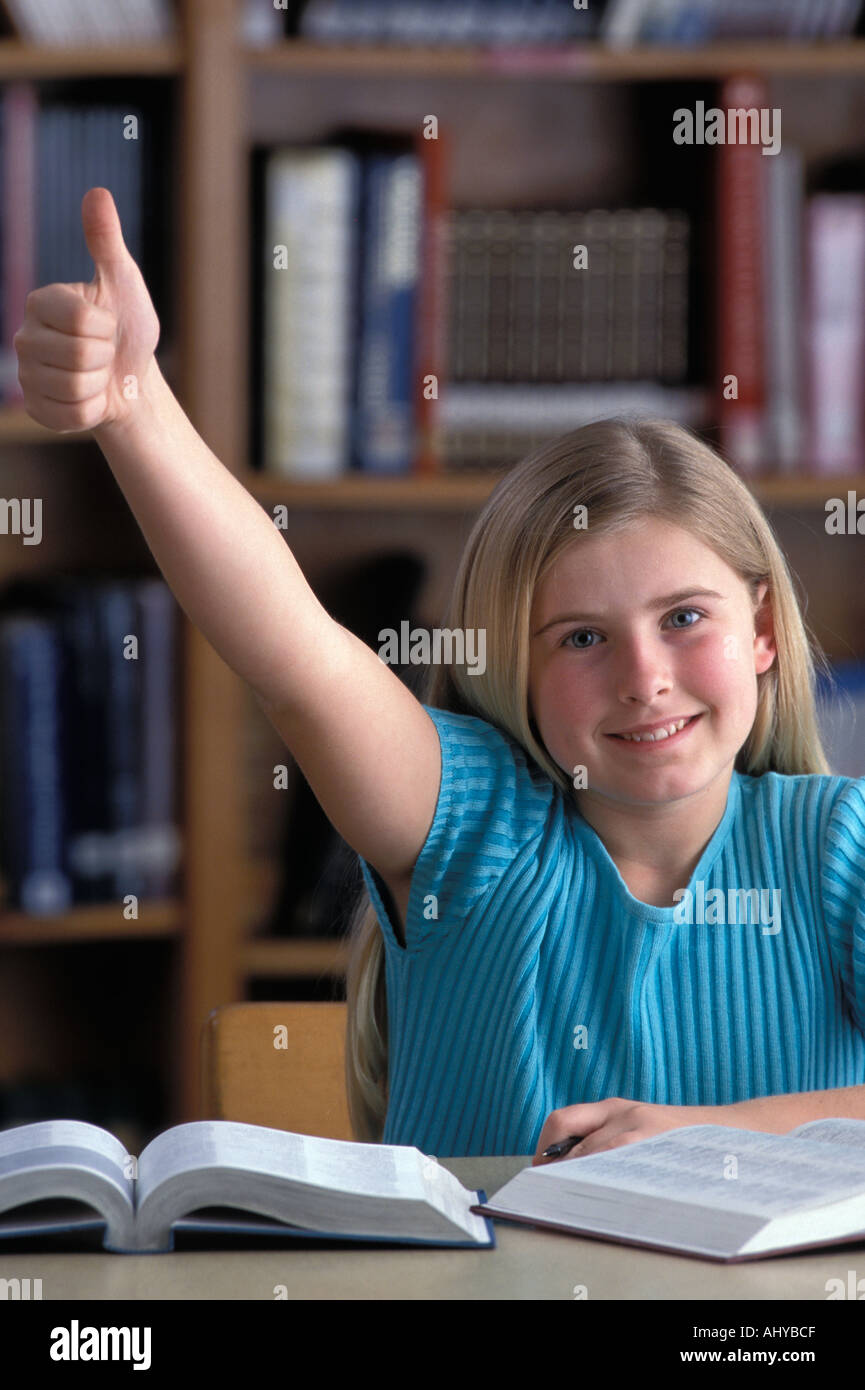 Portrait of a Caucasian female student giving thumbs up in middle ...