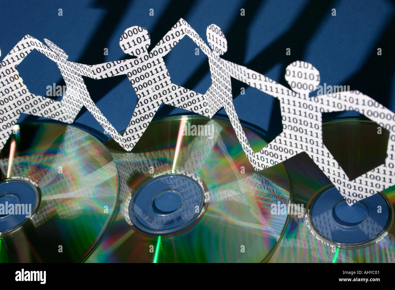 paper doll with binary numbers standing across compact discs Concept IT ...