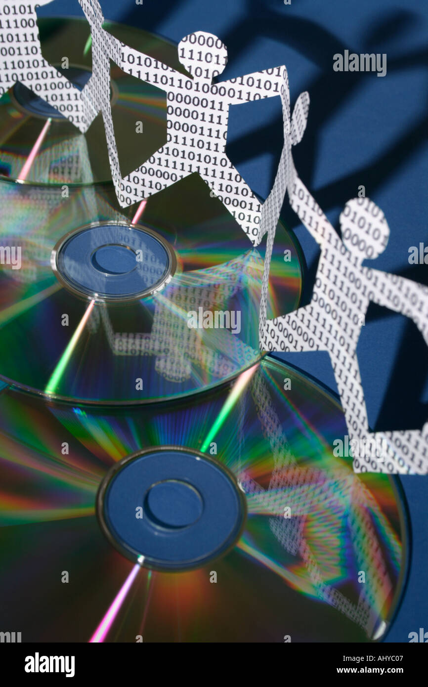 paper doll with binary numbers standing across compact discs Concept IT ...