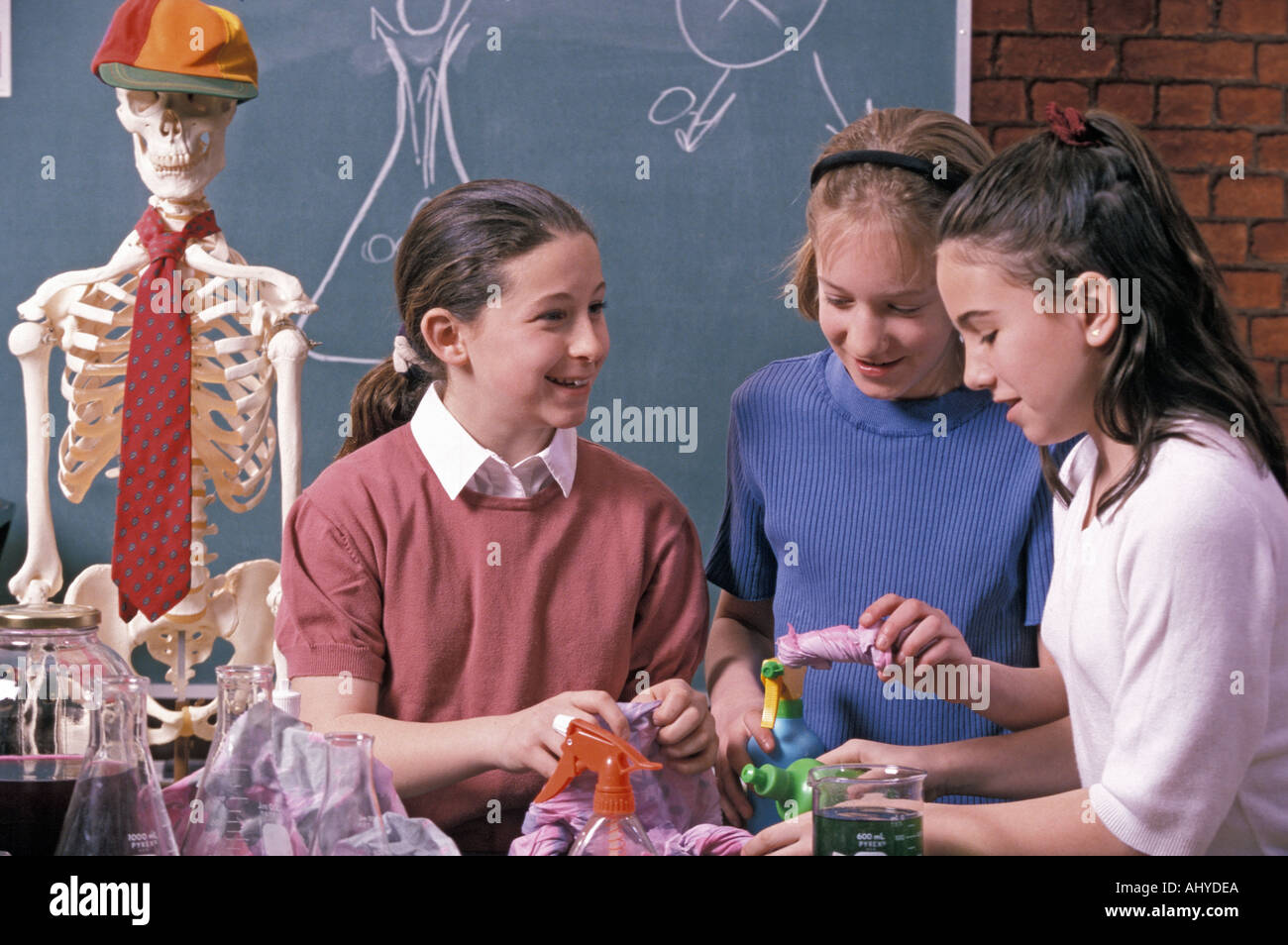 Three Caucasian female students doing science project in middle school ...