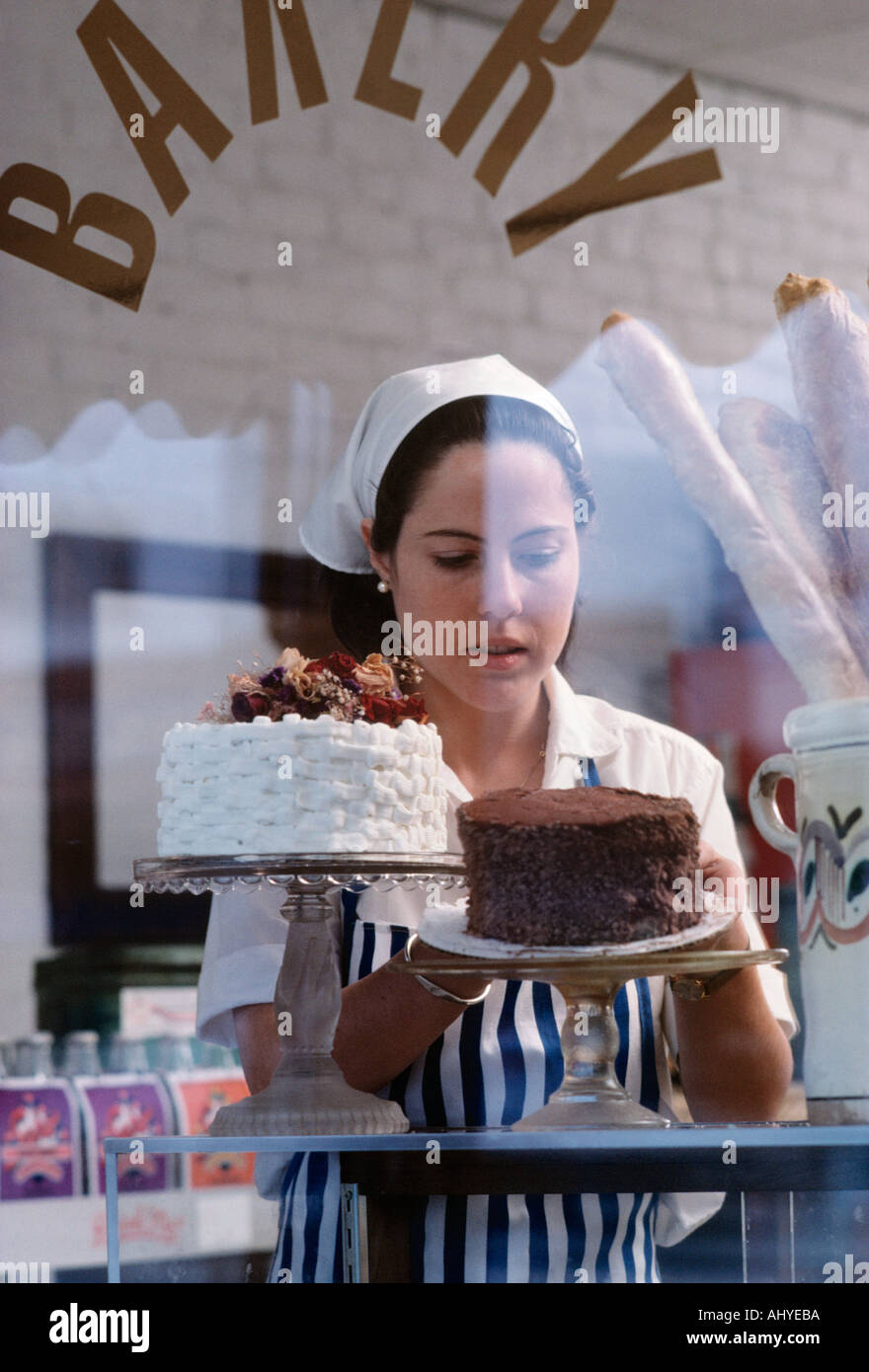 Caucasian Small business owner placing baked goods in retail store ...