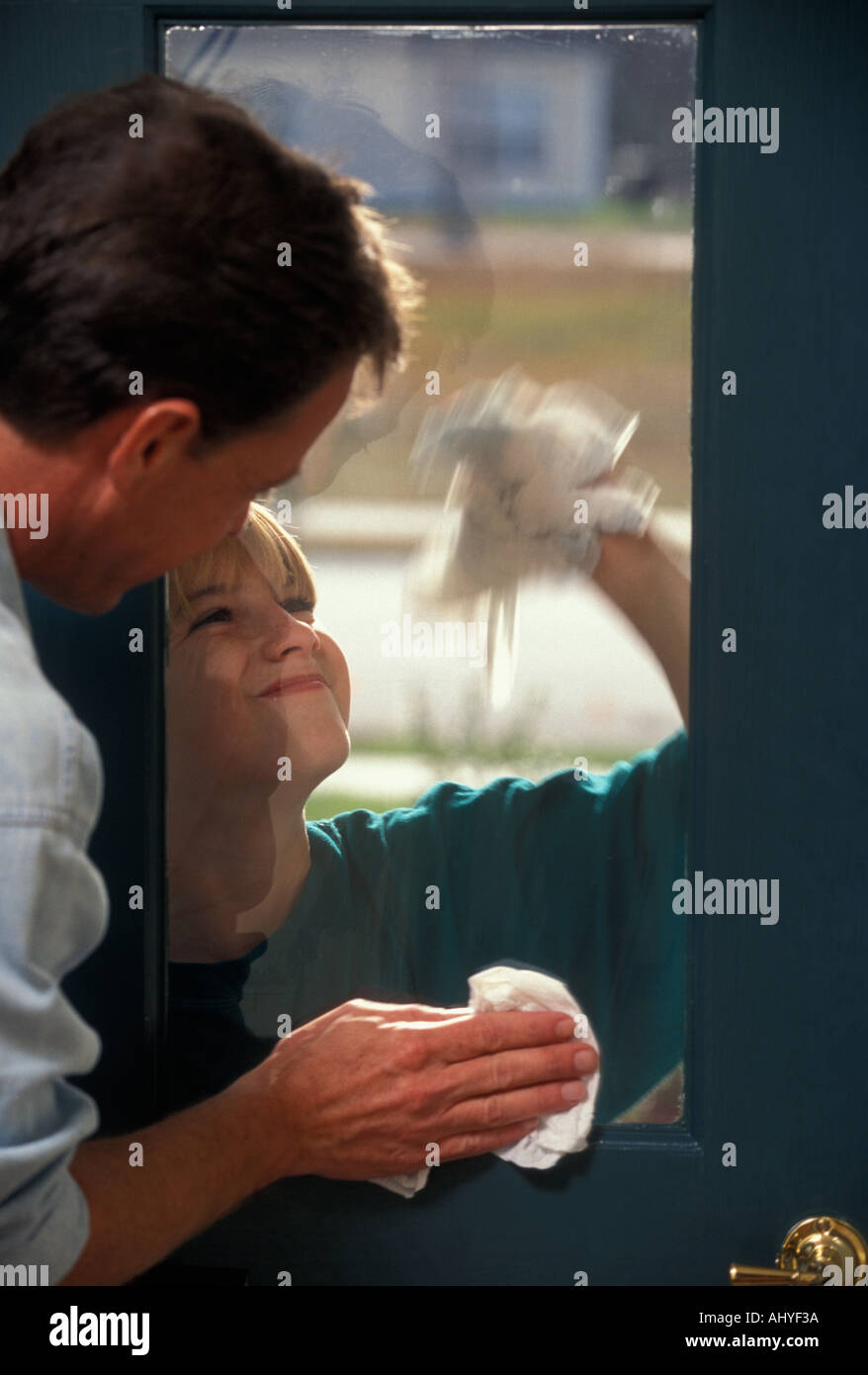 Caucasian father and son Doing chores by washing windows at home Stock ...