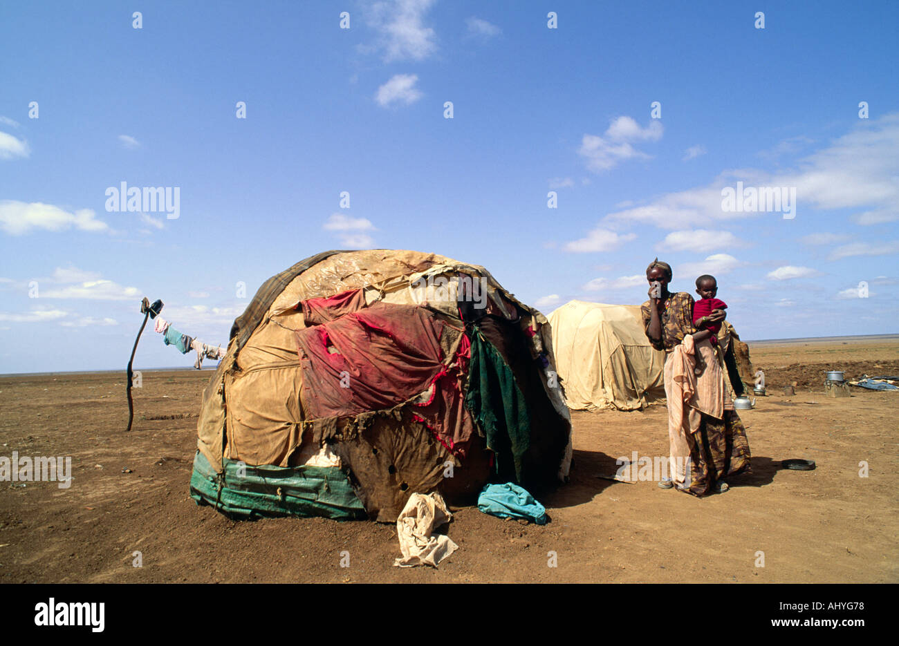 A Somali refugee mother and child outside their bender home on barren ...