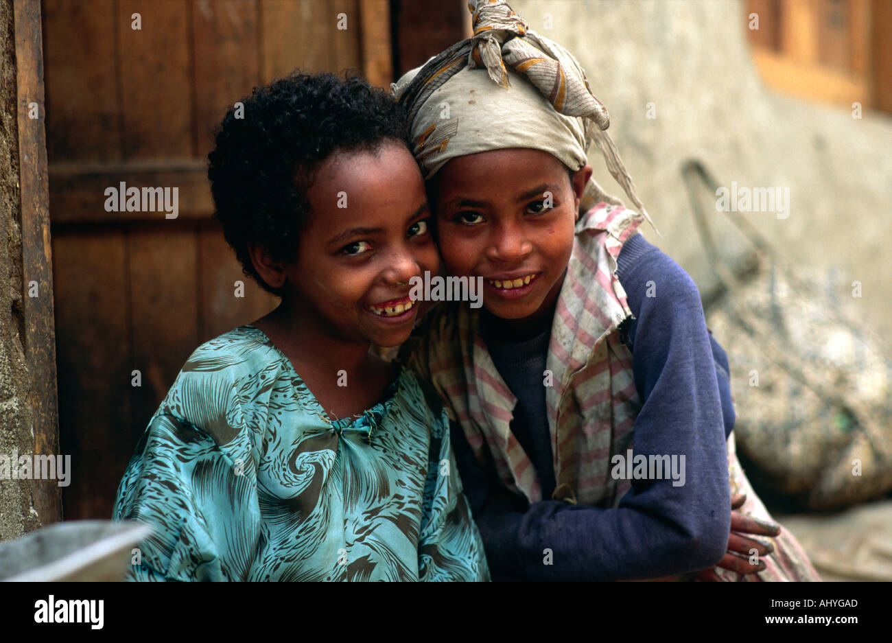 Portrait of two smiling, young girl friends living in a slum area of ...