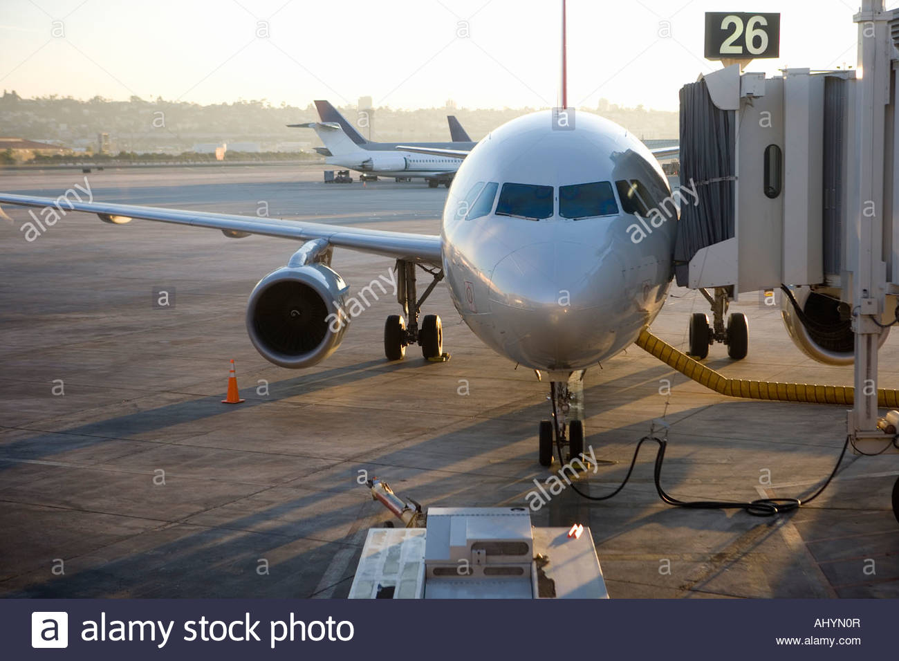 Stationary commercial aircraft at airport boarding gate, front view ...