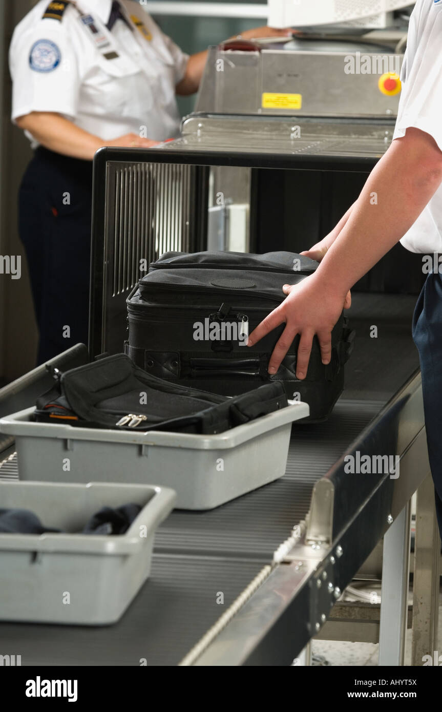 Airport security worker checking baggage Stock Photo - Alamy