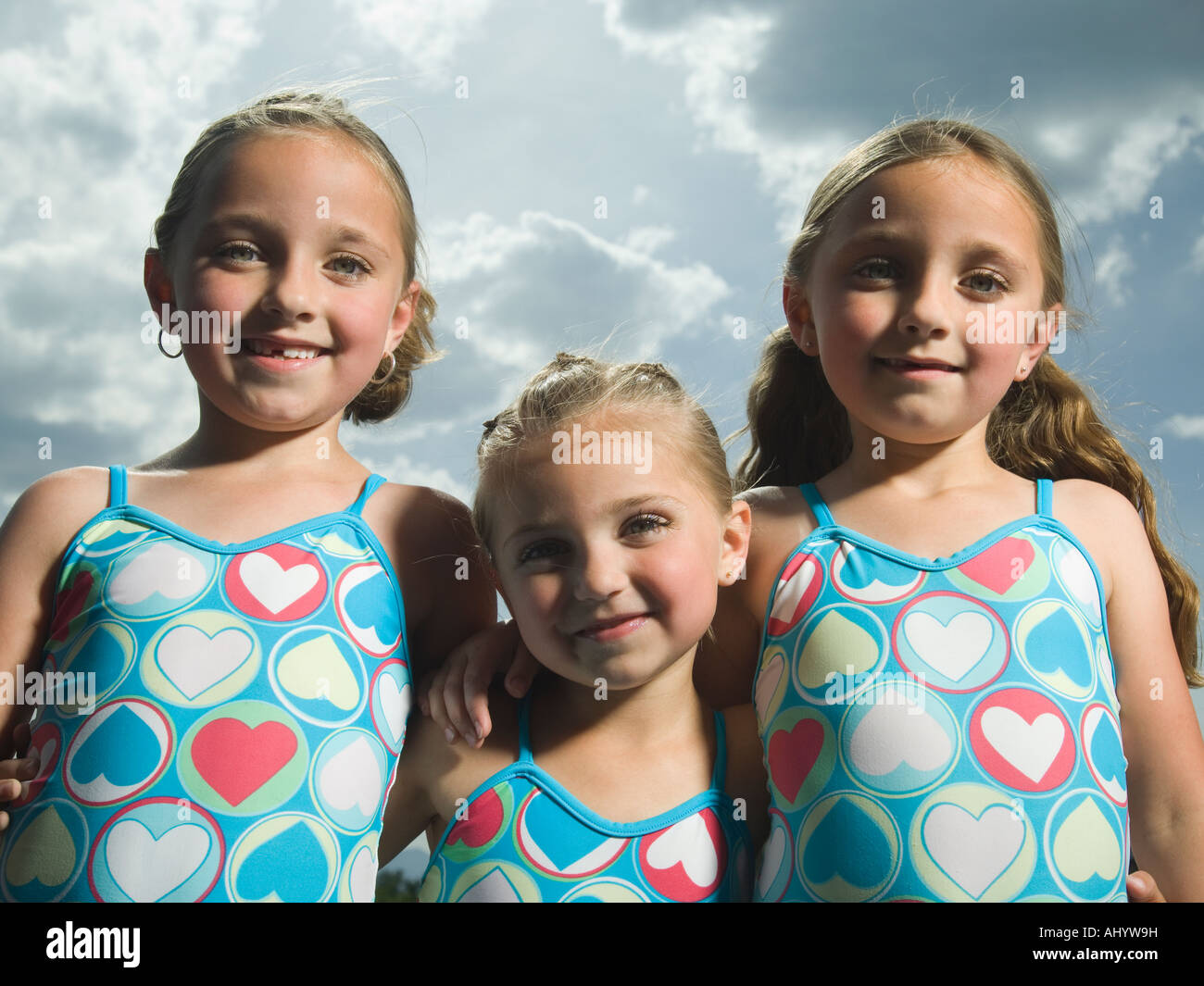 Three young sisters hugging Stock Photo - Alamy