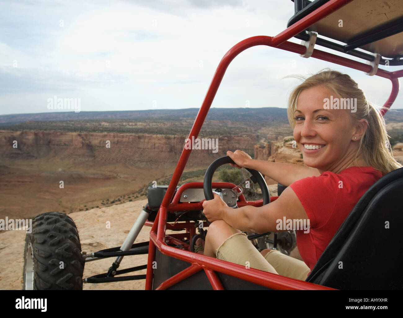 Woman in off-road vehicle at edge of cliff Stock Photo - Alamy