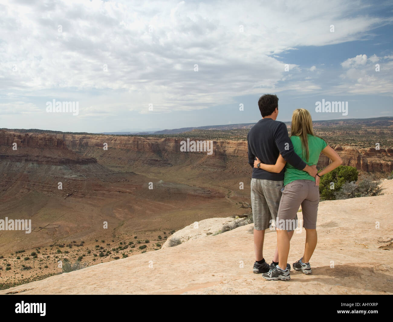 Couple looking over edge of cliff Stock Photo - Alamy