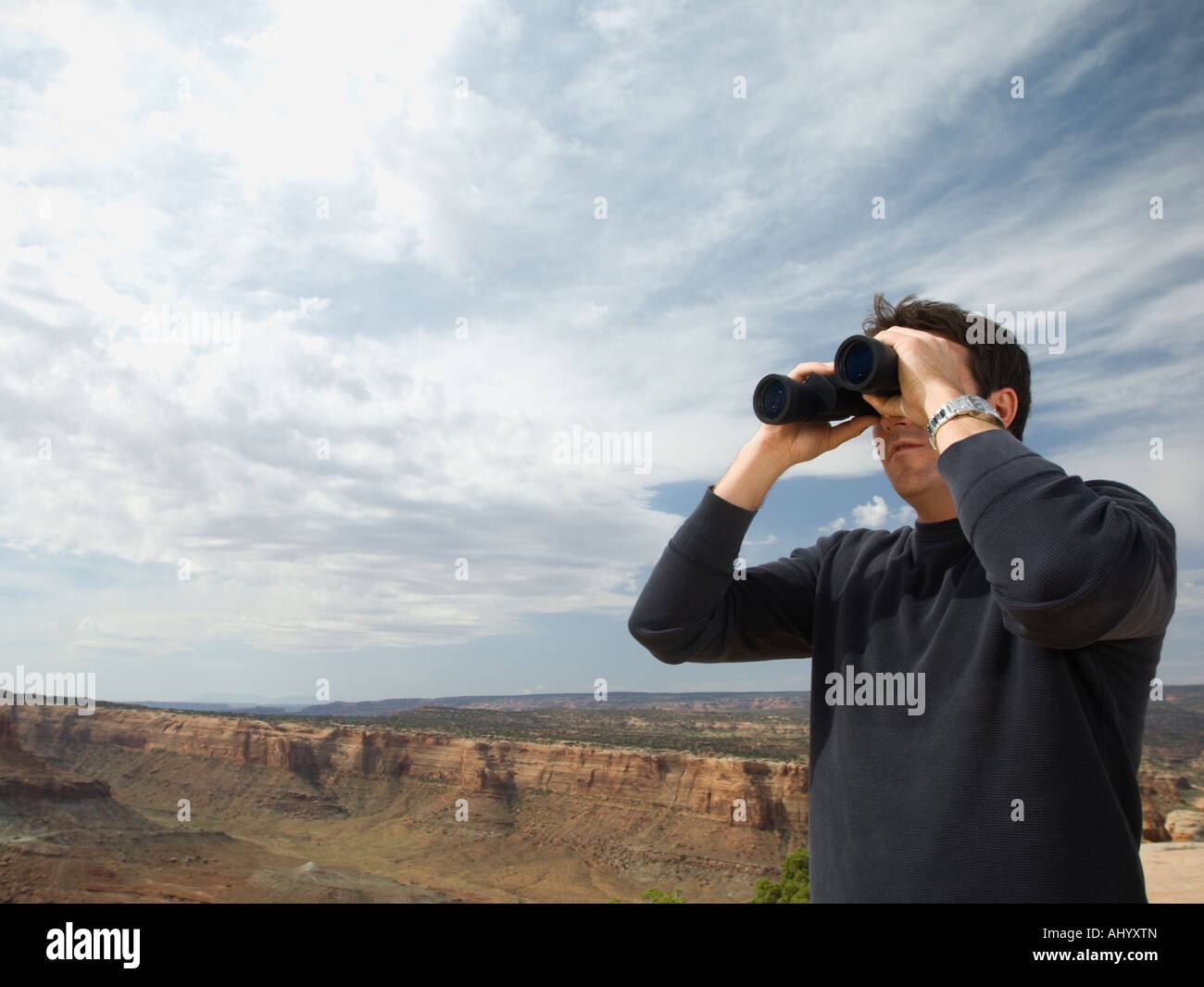 Man looking through binoculars Stock Photo - Alamy