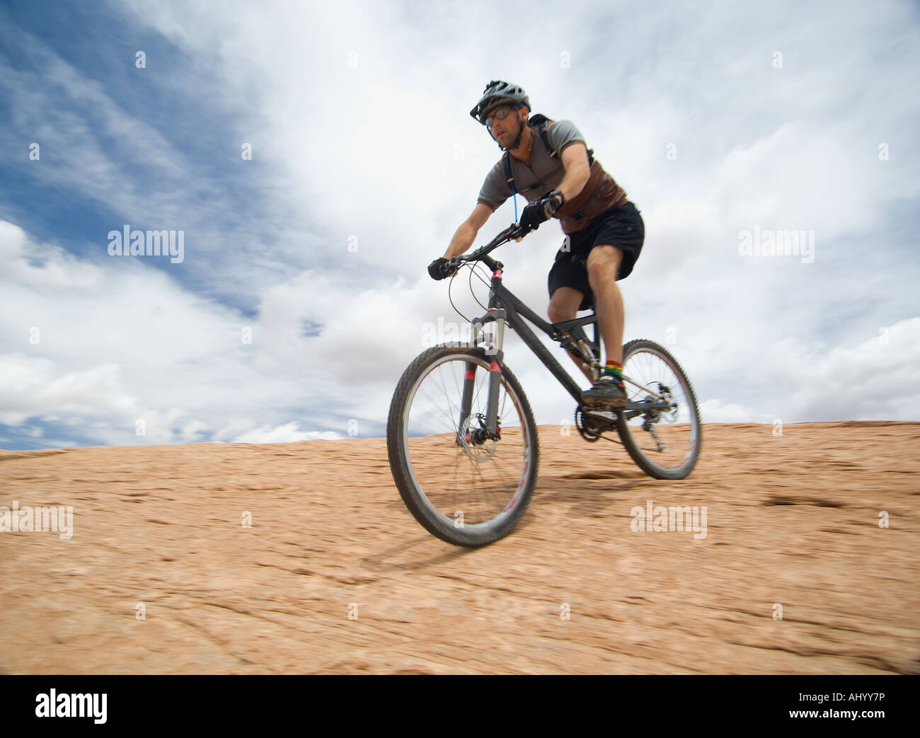 Man riding mountain bike on rock formation Stock Photo - Alamy