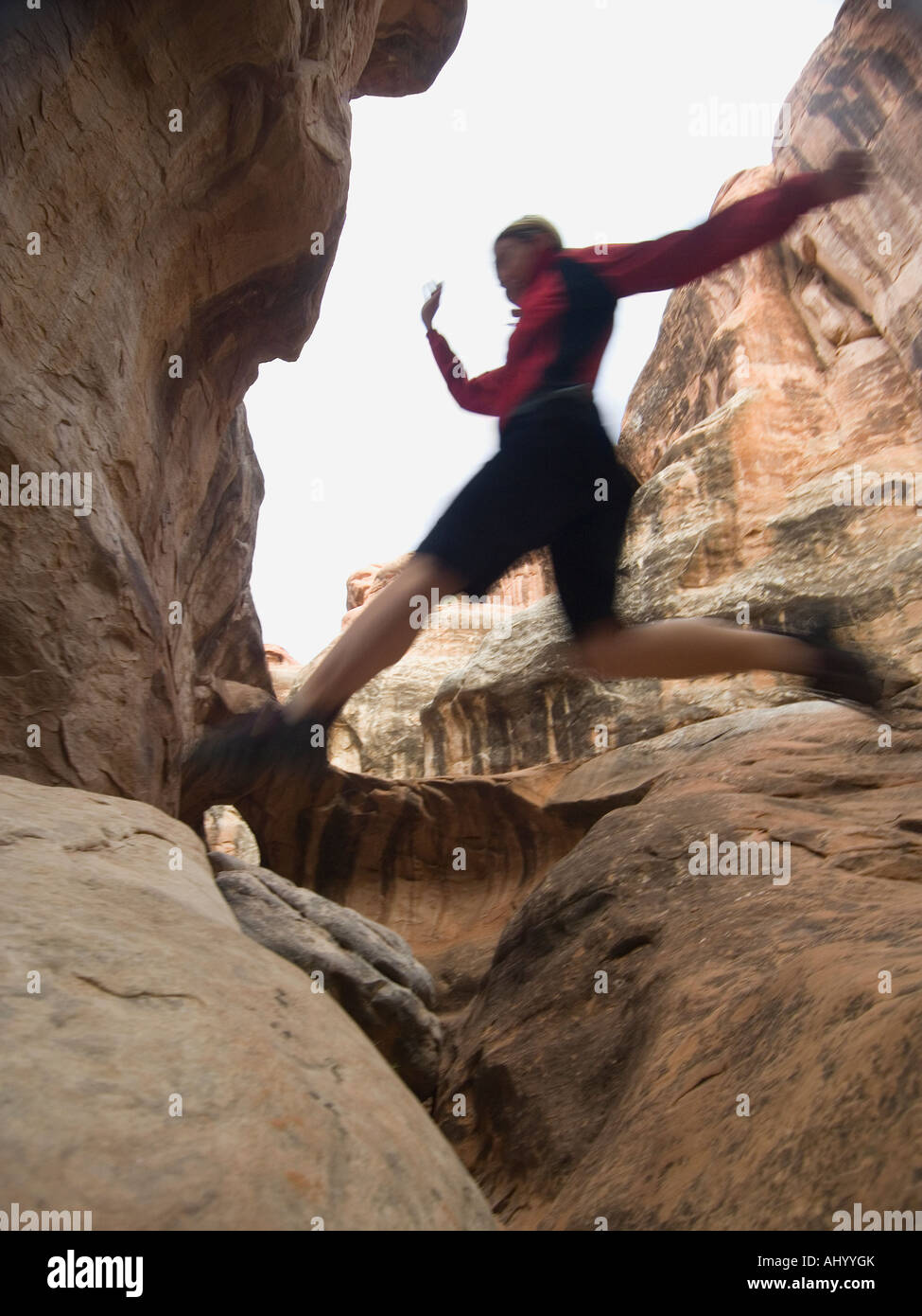 Woman jumping over rock formations Stock Photo - Alamy