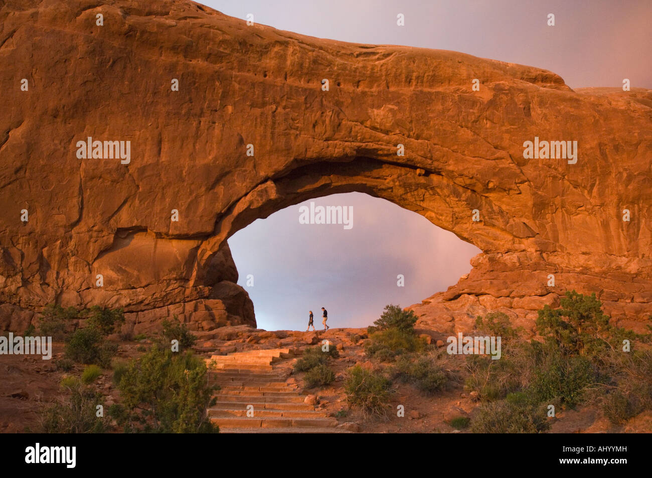 People standing under rock formation Stock Photo - Alamy