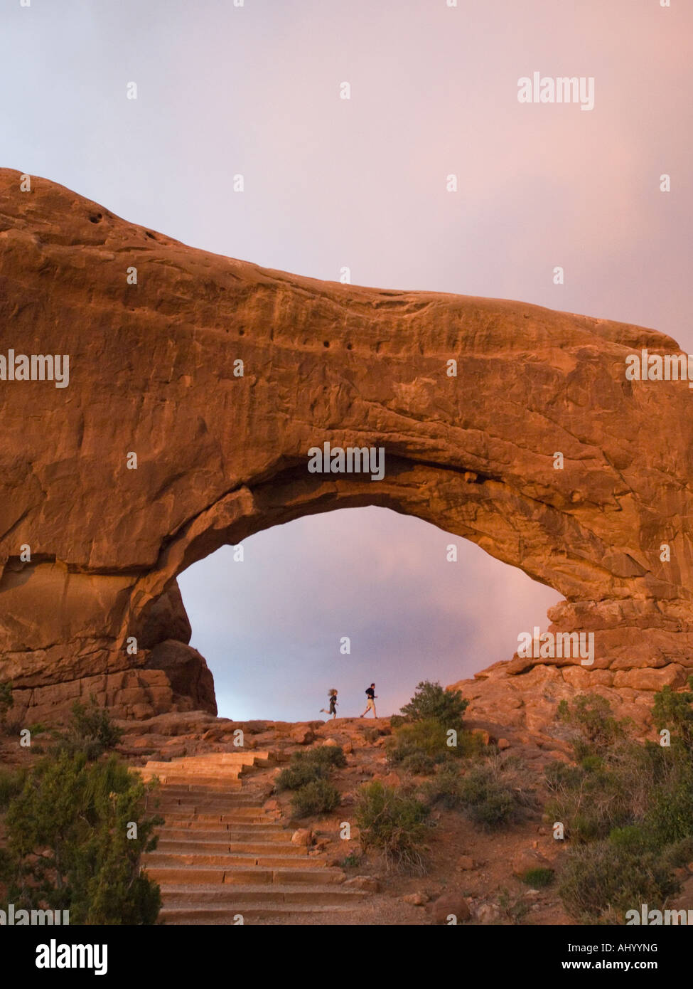 People standing under rock formation Stock Photo - Alamy