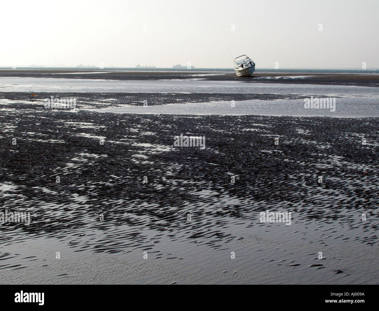 A stranded boat rests on the sand at low tide on Ryde beach, Ryde, Isle ...