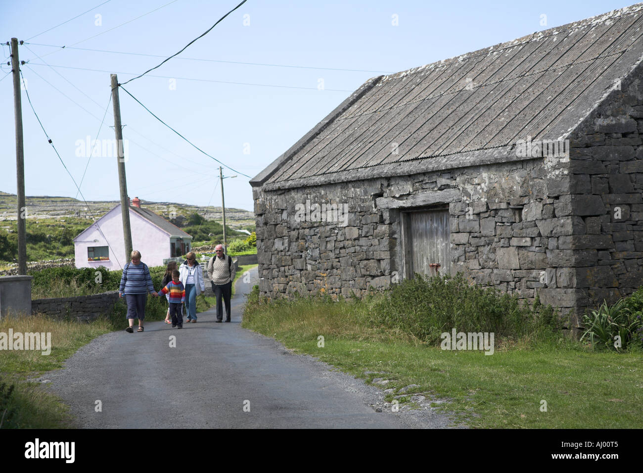 People walking along quiet village road Inishmore Aran Islands Ireland ...