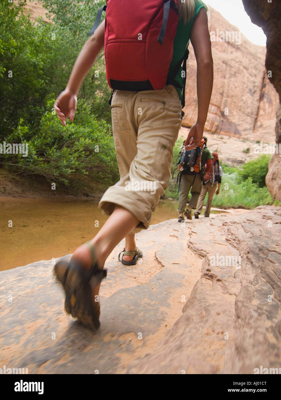 People hiking next to stream Stock Photo - Alamy