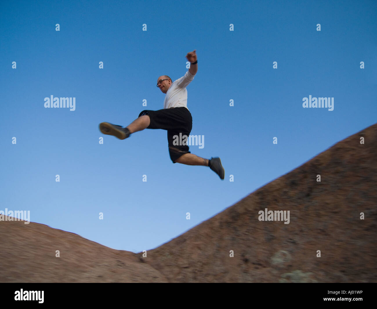 Man jumping over rock formations Stock Photo - Alamy