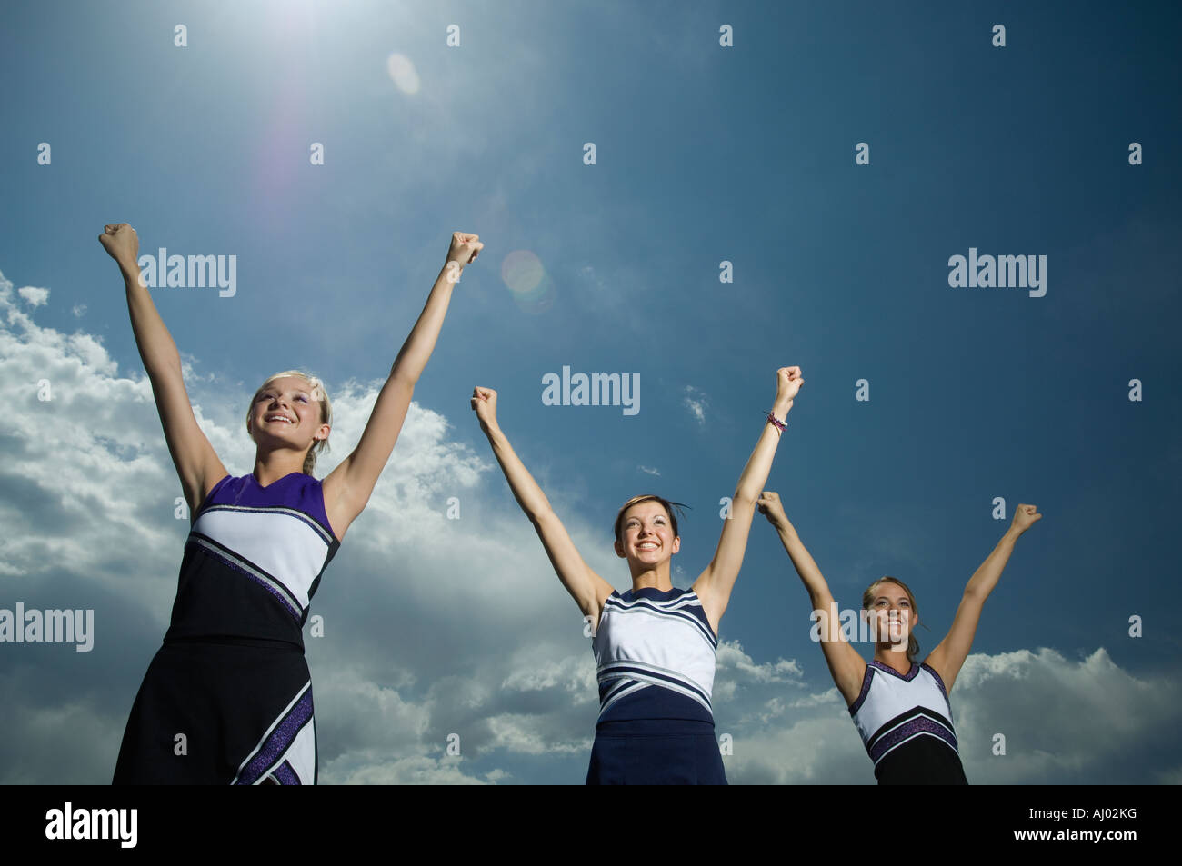 Cheerleaders with arms raised Stock Photo - Alamy