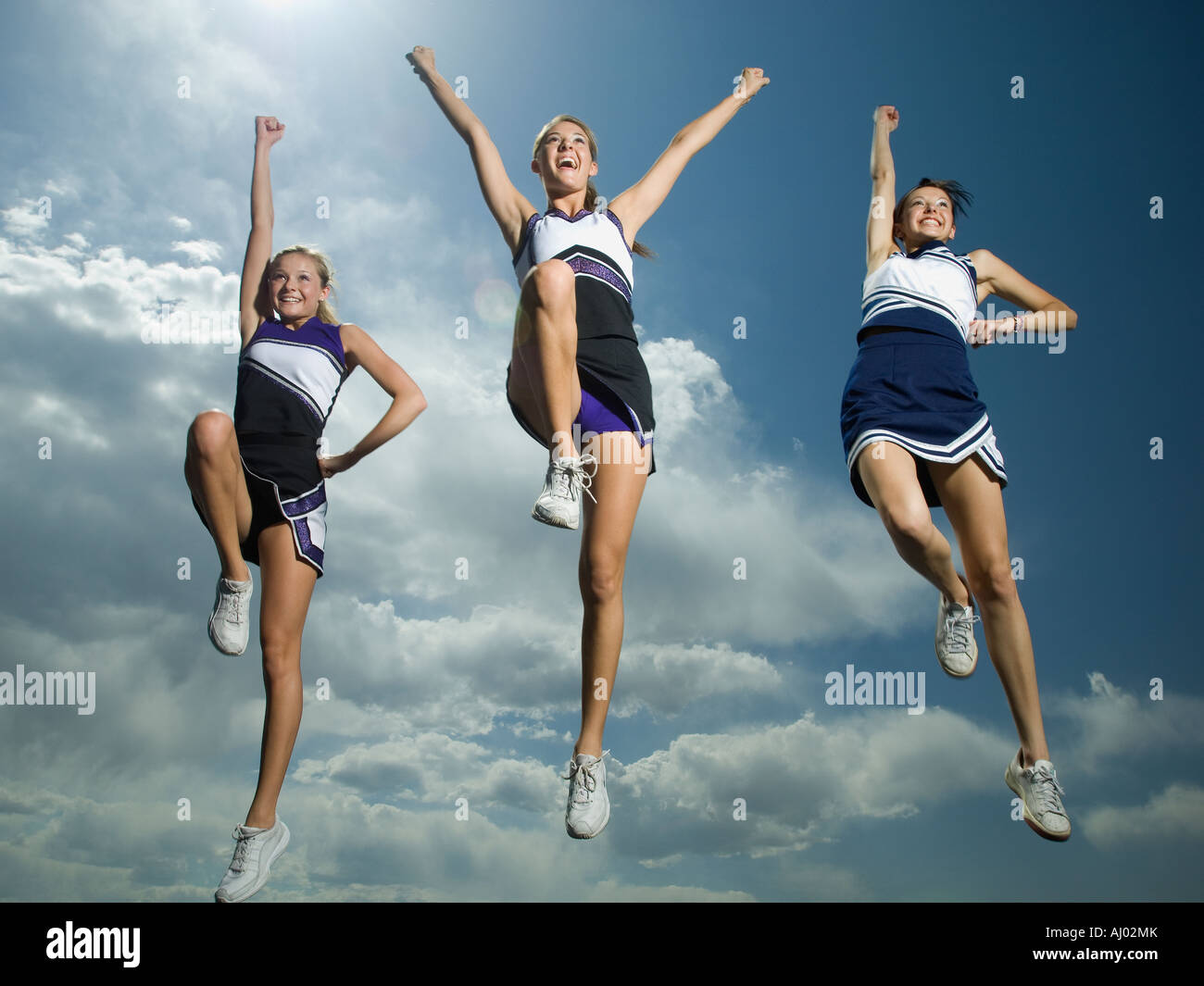 Three cheerleaders jumping Stock Photo - Alamy