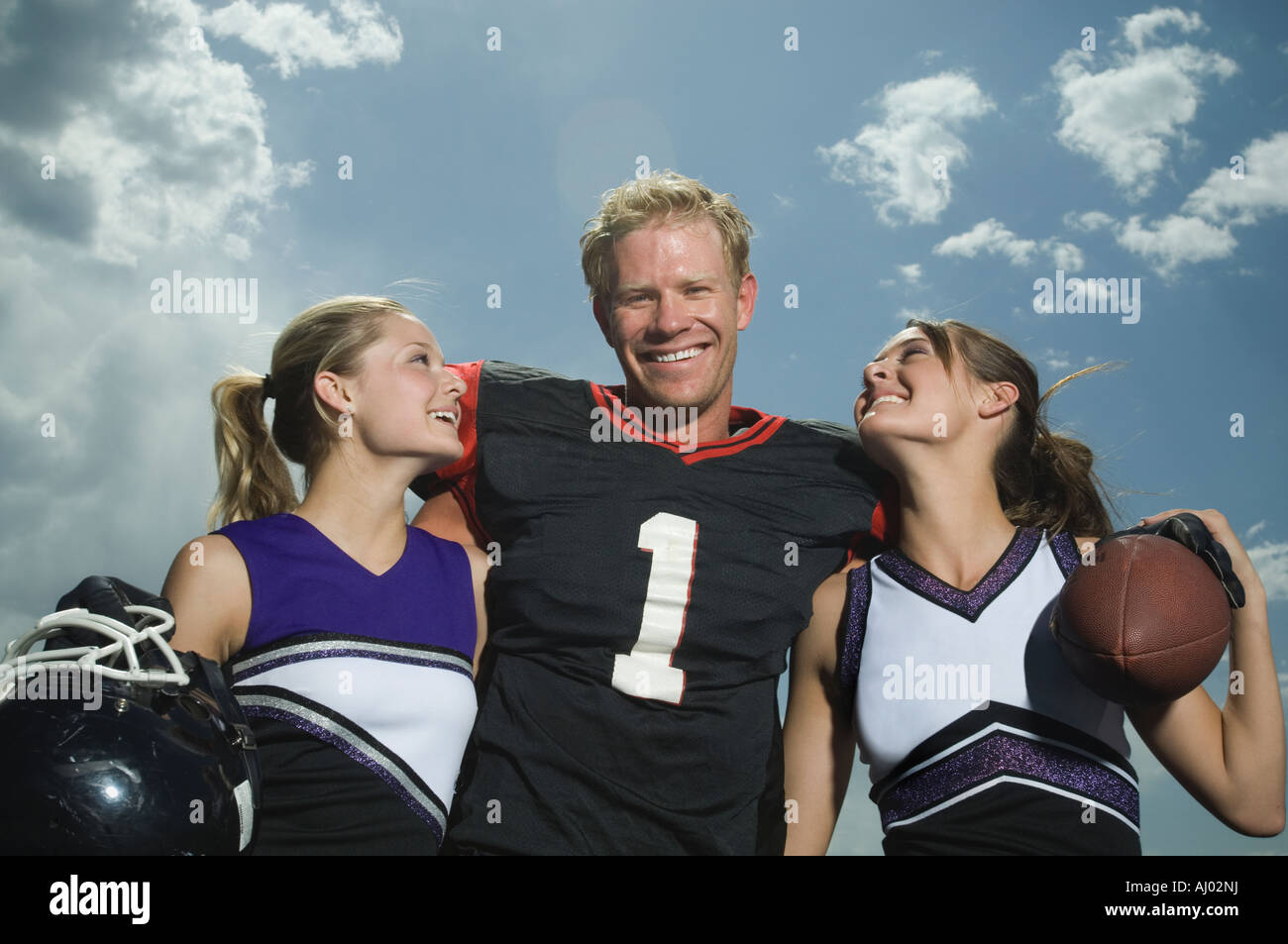 Football player hugging cheerleaders Stock Photo - Alamy