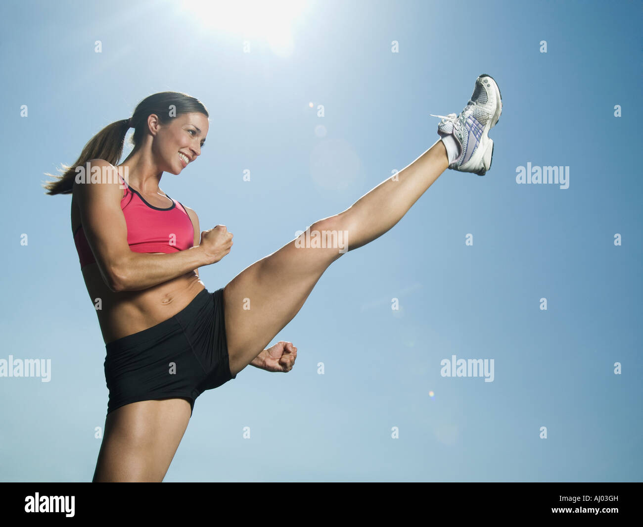 Woman in athletic gear kicking Stock Photo - Alamy
