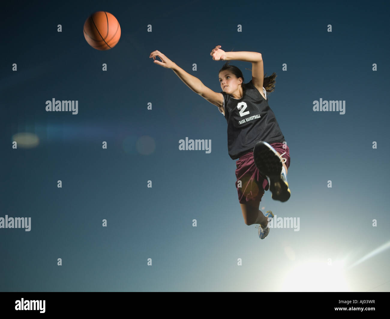 Girl jumping with basketball Stock Photo - Alamy