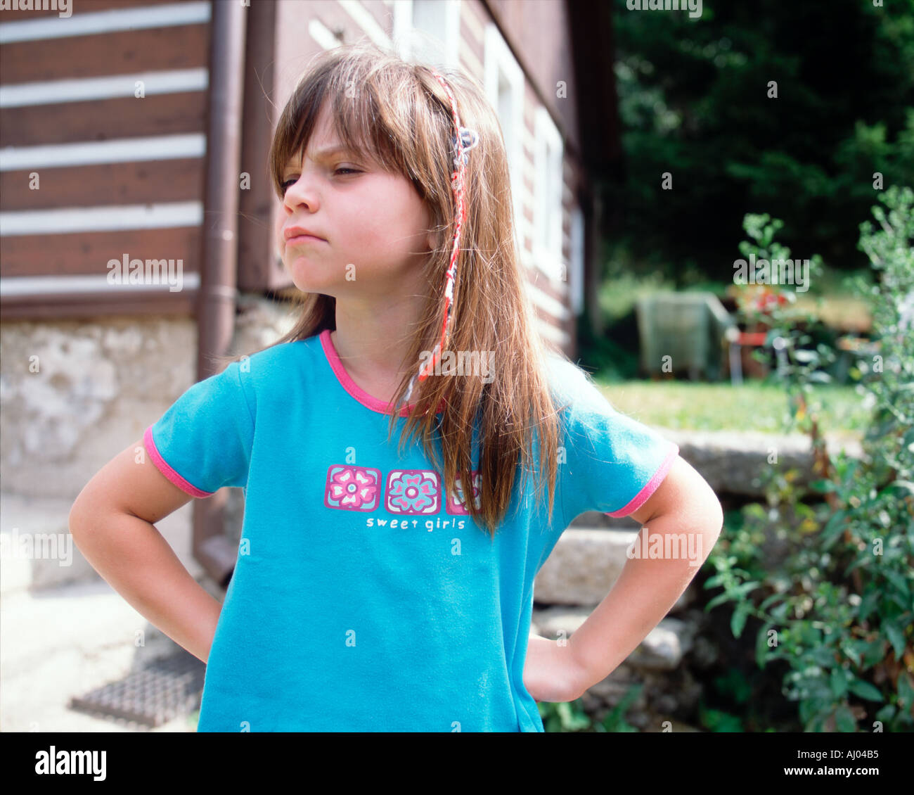 Angry Seven Year Old Girl in summertime wearing turquoise t shirt Stock ...