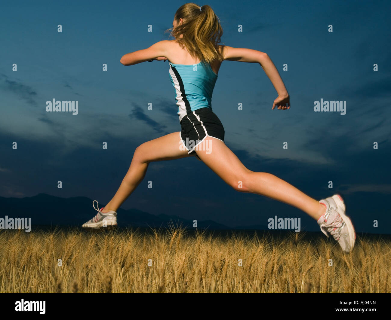 Woman in athletic gear jumping Stock Photo - Alamy