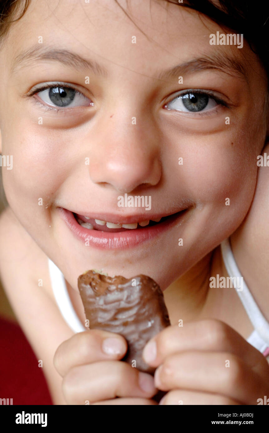 a pretty young girl eating a bar of chocolate Stock Photo - Alamy