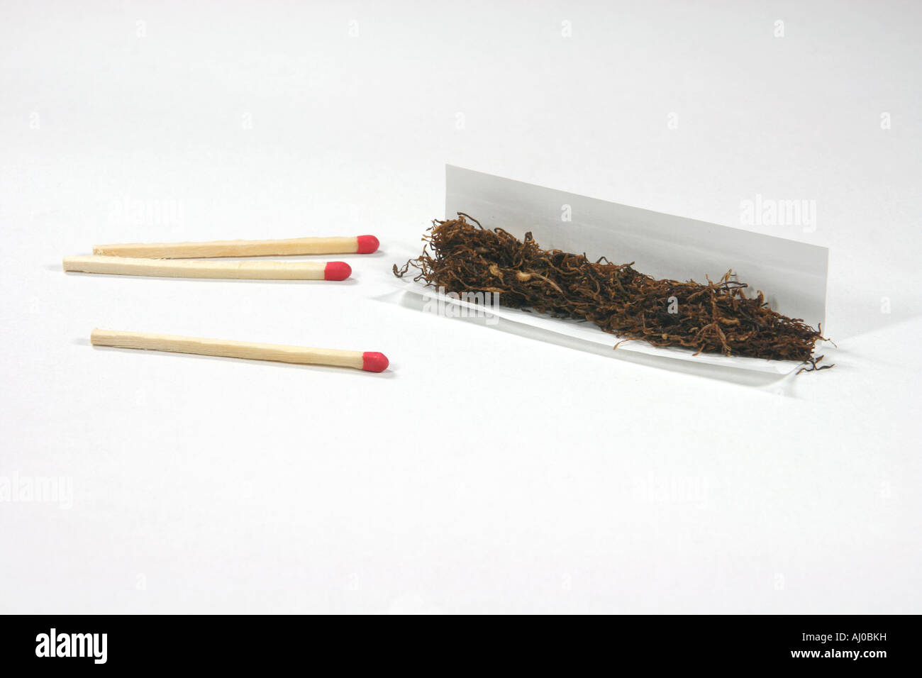 rolling cigarette with matches in white background Stock Photo - Alamy