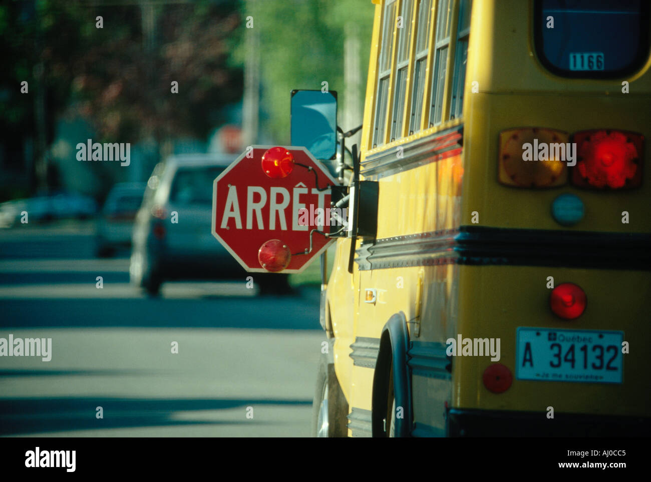 Yellow school bus in Quebec stopped with its Arret stop in French sign ...