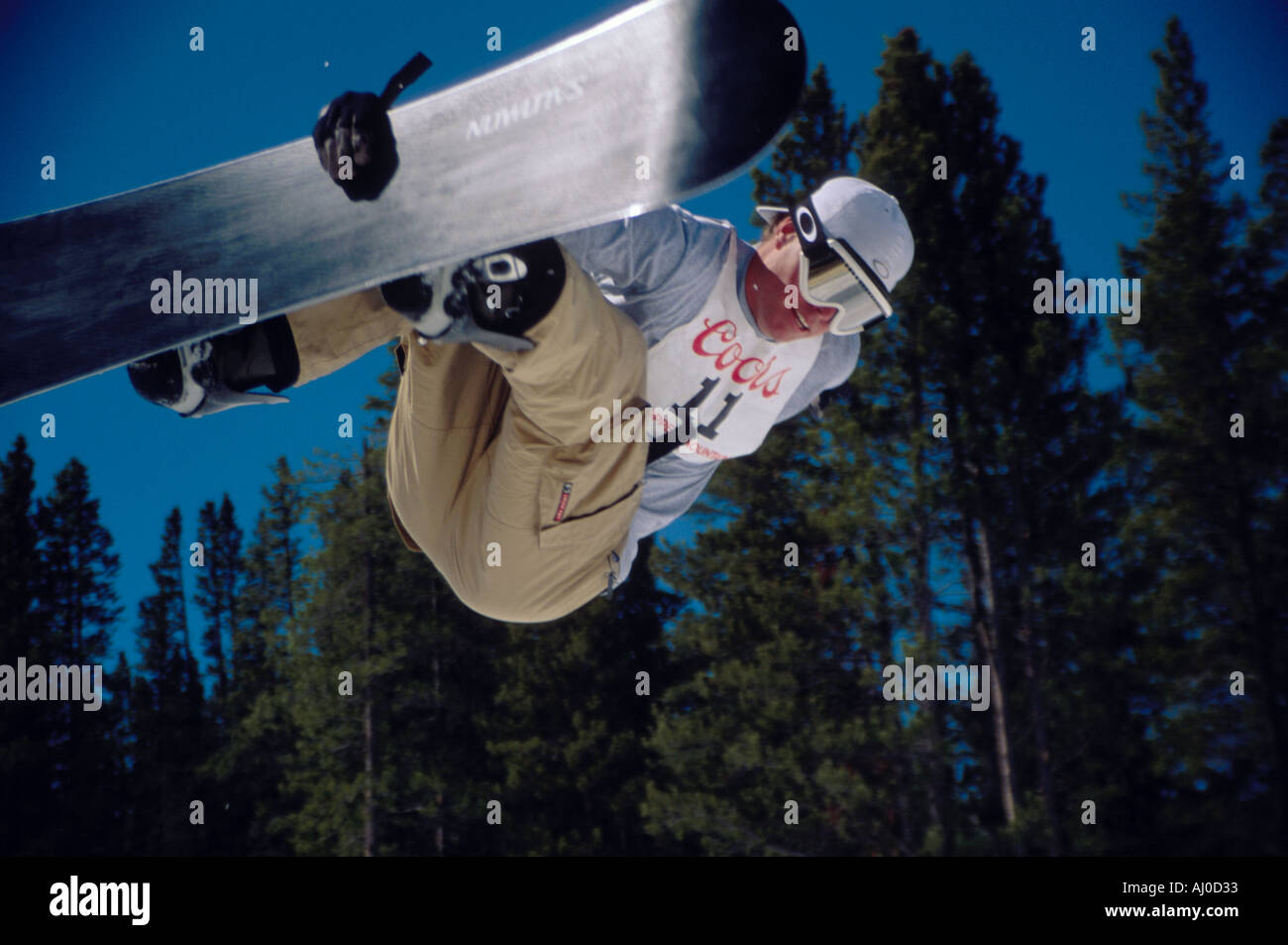 Leaping snowboarder in midair competing in a half pipe contest at ...