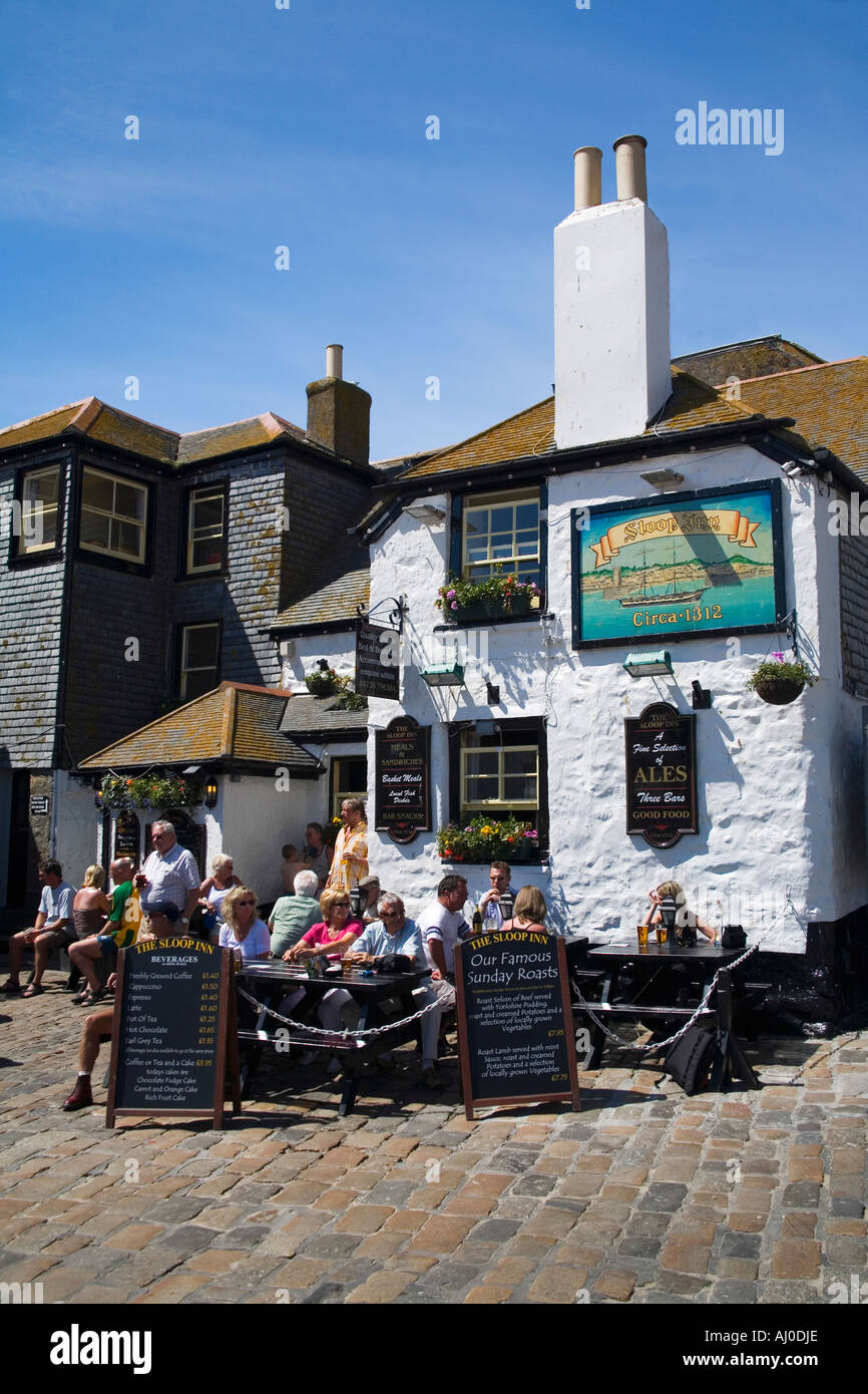 Tourists enjoy drinking outside in summer sun sunshine at the Sloop Inn ...