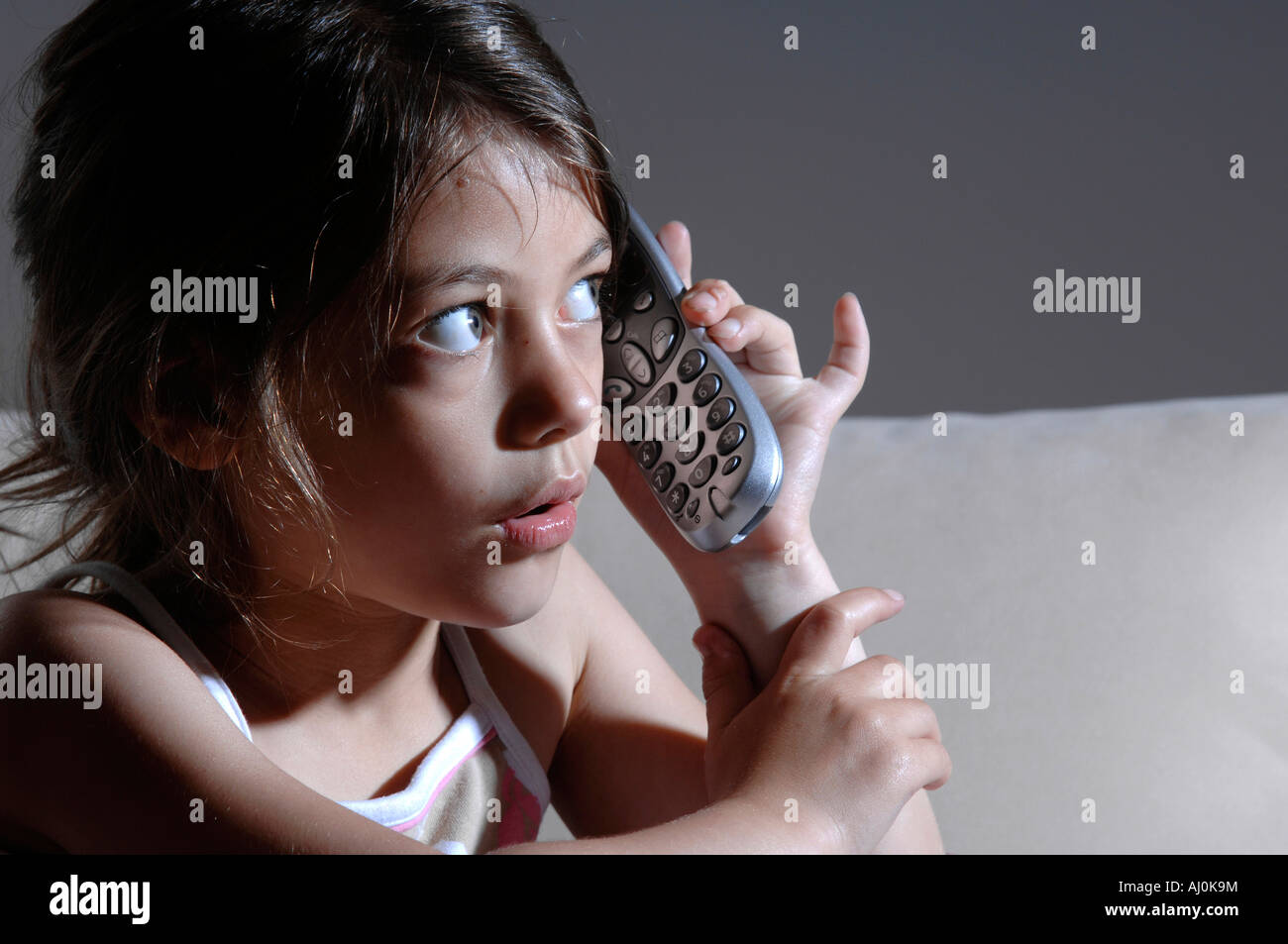 an attentive young child talking on phone Stock Photo - Alamy