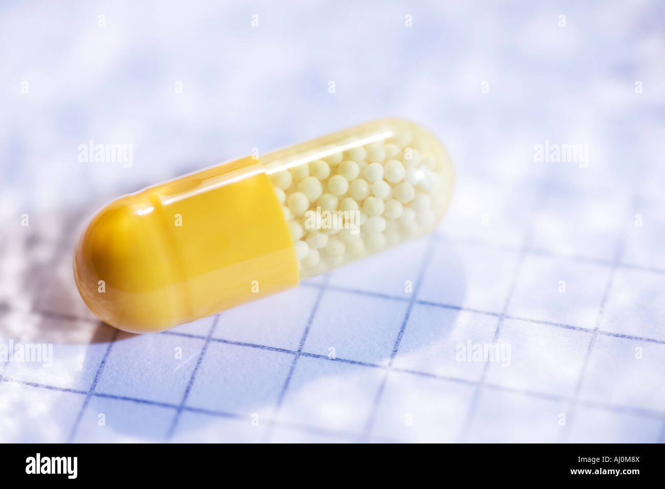 Yellow capsule filled with grains Stock Photo - Alamy