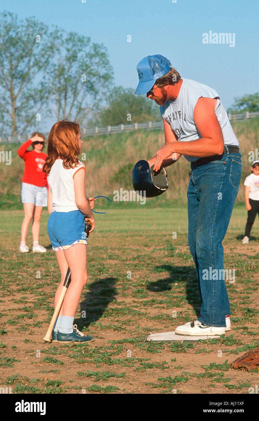 A man coaching a girls softball game IN Stock Photo - Alamy