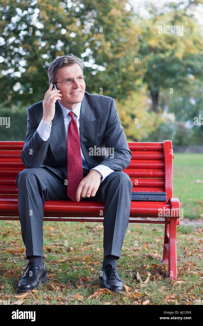 Sitting on park bench with cell phone hi-res stock photography and ...