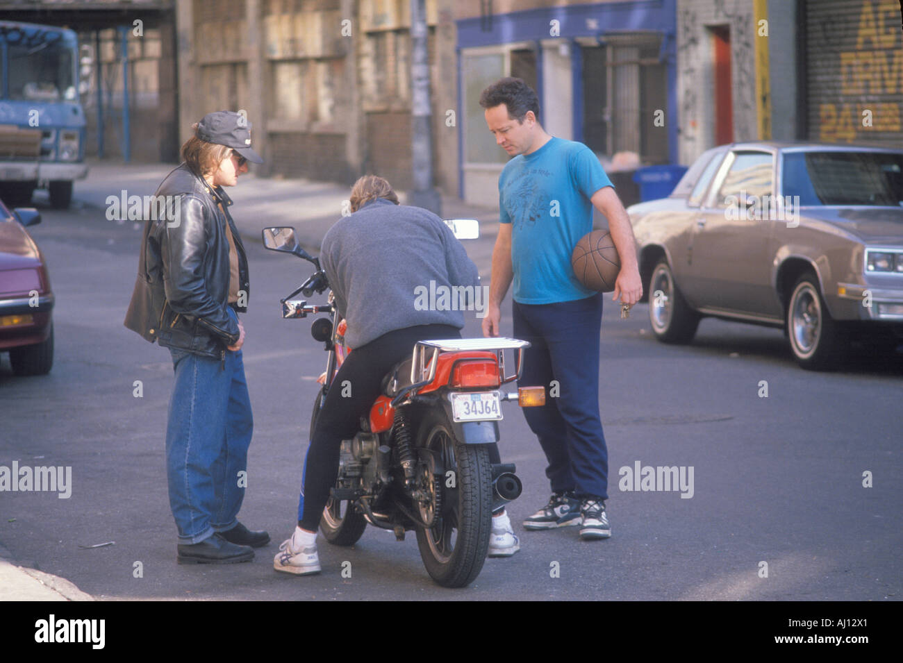 Three men with a motorcycle on a NY City street Stock Photo - Alamy